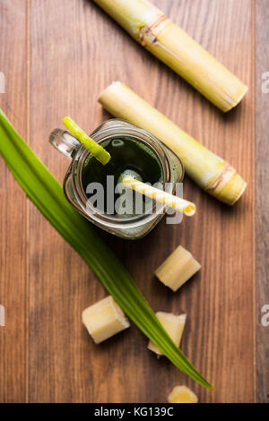 sugar cane juice or "ganne ka ras" with cut pieces cane on white ...
