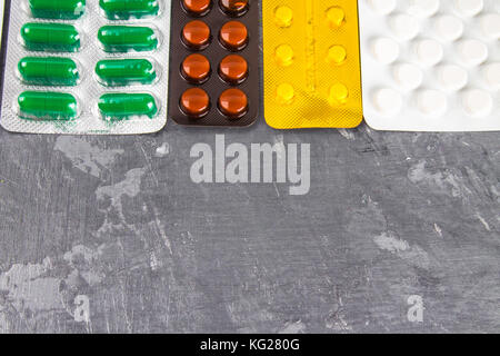 Multicolored blisters of tablets on a gray concrete background Stock ...