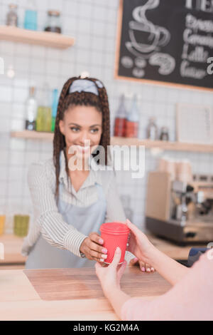 A customer is receiving their order at the coffee shop counter ...