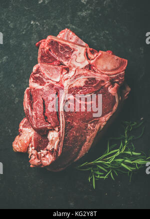 Fresh raw beef steak placed on rustic wooden cutting board surrounded ...