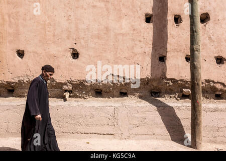 A group of Berber men in traditional blue dress are standing in the ...