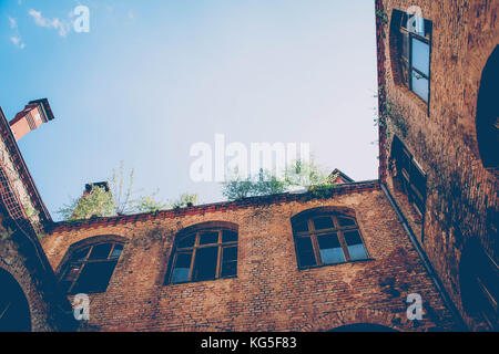 Low angle shot of a brick building with chimneys under a bright sky ...