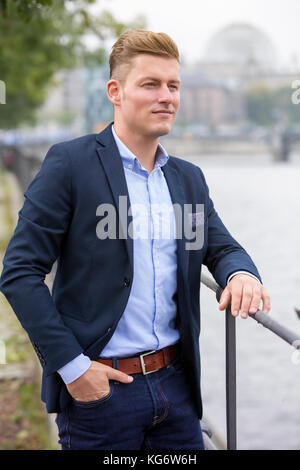 Portrait of an attractive blond german model with a brown sweater on a ...