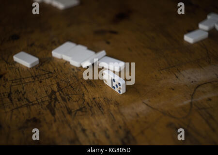 Falling domino on old outdoor table waiting for game Stock Photo - Alamy