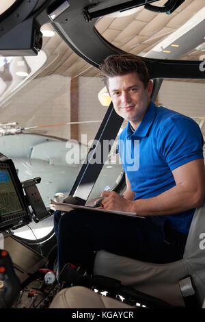 Portrait Of Male Aero Engineer With Clipboard Working In Helicopter ...
