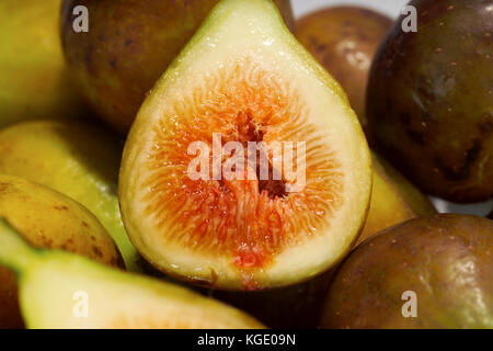 Fresh fig cut open showing the flesh and seeds inside on bed of ...