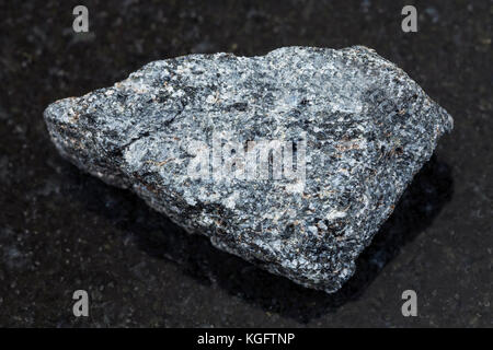 raw nepheline syenite stone on dark background Stock Photo - Alamy