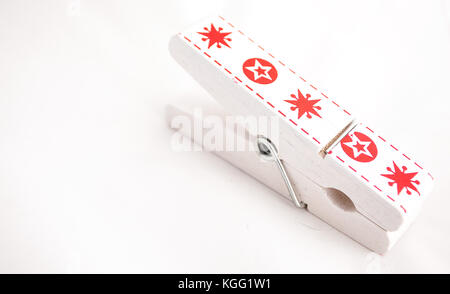 White and red wooden decorated pegs on a white background in studio ...