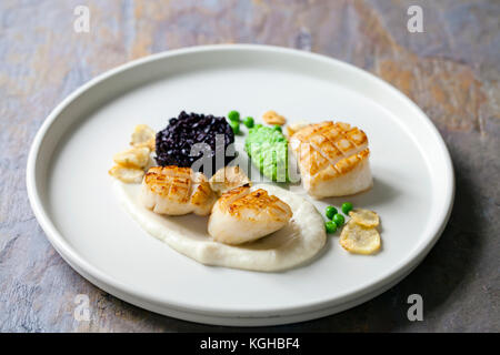 Scallops with black forbidden rice and pea puree Stock Photo - Alamy