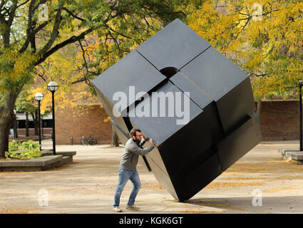 A man pushes a giant cube on the University of Michigan campus in Ann ...
