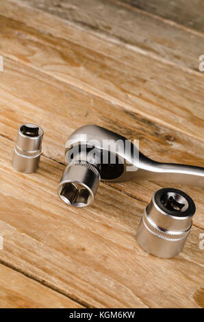 Ratchet wrench and different sized sockets on a wooden work bench Stock ...