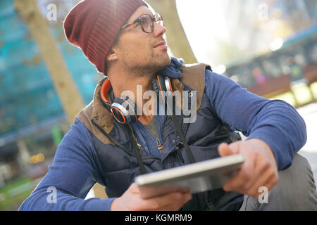 Hipster guy in the street websurfing on tablet Stock Photo - Alamy