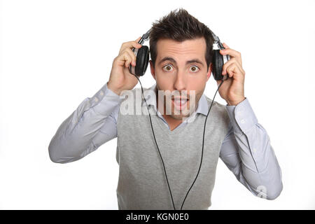 Surprised man taking off headphones for music isolated on white studio ...
