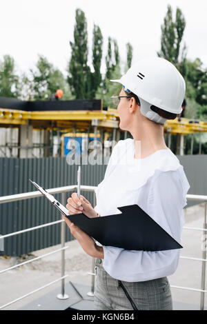 attractive businesswoman in hardhat and safety vest using laptop Stock ...