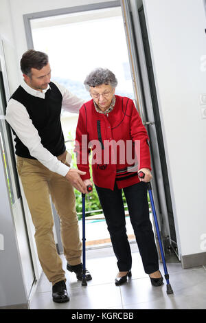Injured man with crutches recovering at home Stock Photo - Alamy
