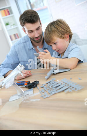 Caucasian kid playing with toy plane on sky background outside on ...