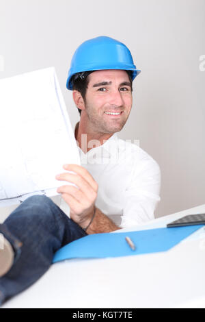 Relaxed architect in office with construction plan Stock Photo - Alamy