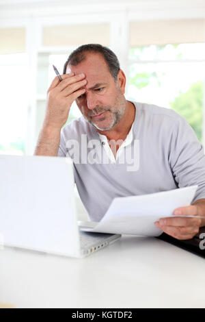 Senior man being puzzled with tax documents Stock Photo - Alamy