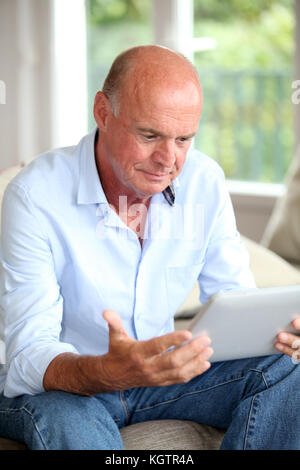 Senior man at home using electronic tablet Stock Photo - Alamy