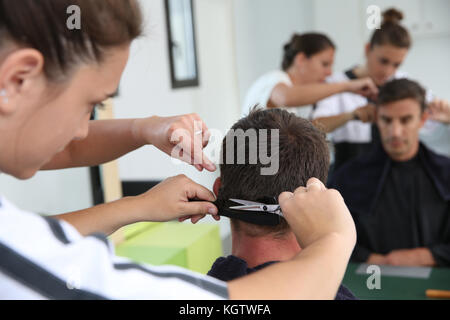 Student girl in hairdressing learning how to cut hair Stock Photo - Alamy