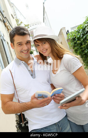 Couple of tourists using guide and tablet in town Stock Photo - Alamy