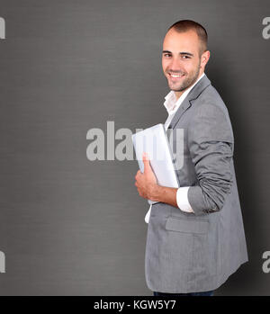 Cool businessman using touchpad on grey background Stock Photo - Alamy