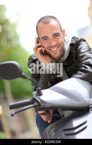 Adult man in moto jacket with helmet is choosing gloves in the moto ...
