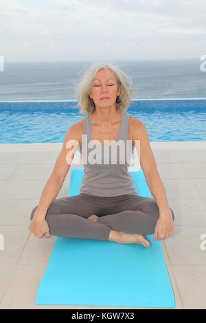 Senior woman doing exercises by a swimming-pool Stock Photo - Alamy
