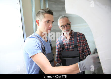 Young apprentice with professional plasterer Stock Photo - Alamy