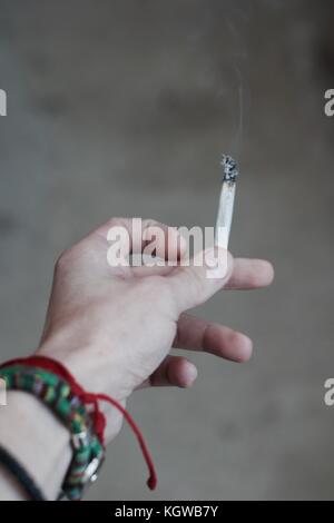 Small spliff in man hand. Marijuana smoking concept Stock Photo - Alamy