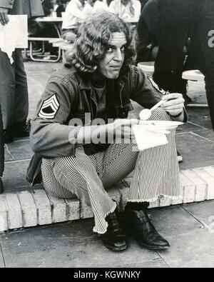 Student in hippie attire, including a t-shirt with a caricature of ...
