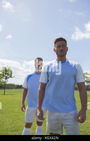 Football players standing in ready position on ground Stock Photo - Alamy