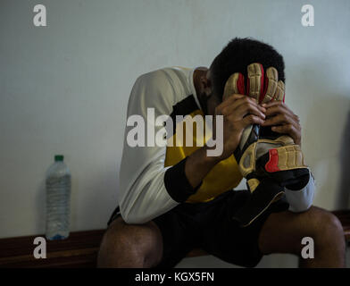 Sad football player sitting on bench in changing room Stock Photo - Alamy