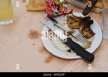 Messy table after party. Leftover food, spilled drinks, dirty dishes ...