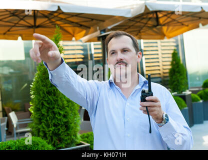 Security guard hand holding cb walkie-talkie radio Stock Photo - Alamy