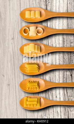 Raw fusilli and wooden spoons on blue background Stock Photo - Alamy