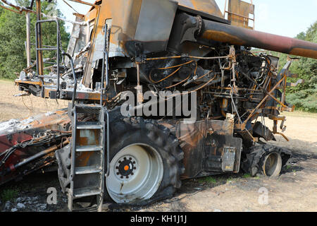 Burnt out combine harvester in field Stock Photo - Alamy