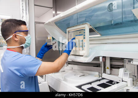 Practioner installing new test tubes to machine for blood tests in ...