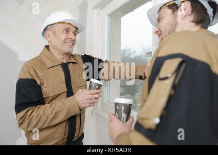 Construction workers and engineer enjoying coffee break at construction ...