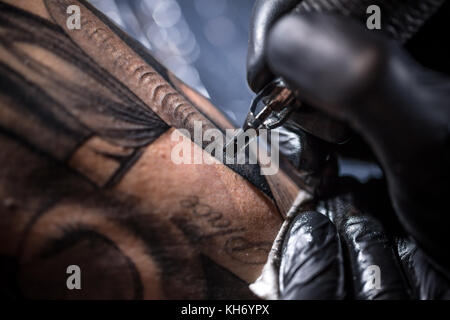 Close up of tattoo artist tattooing her client at the studio Stock ...