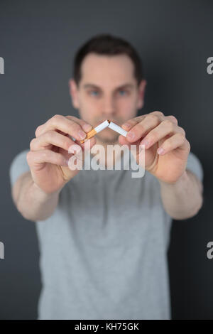 handsome man quitting smoking breaking his last cigarette Stock Photo ...