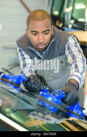 Mechanic fitting new windscreen Stock Photo - Alamy