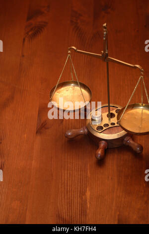 Scales of justice on light wooden table against gray background Stock ...