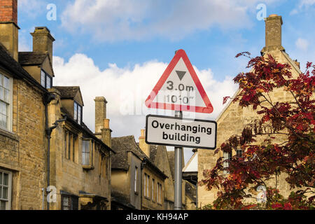 Warning road sign for overhanging building and balcony in town of ...
