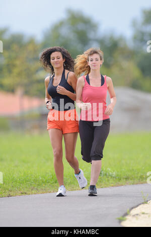 Two women jogging in a park Stock Photo - Alamy
