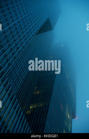 Close up shot of skyscrapers with blue glass walls surrounded by trees ...
