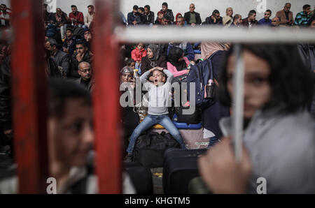 Palestinians gather at a makeshift bus station in a basketball court as ...