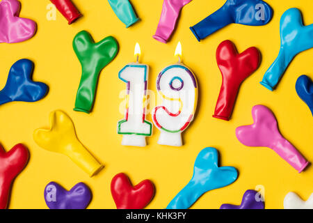 Number 19 celebration candle with party confetti Stock Photo - Alamy