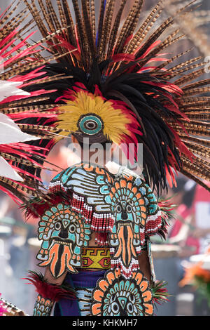 A Mexican man, wearing a colorful feather mask inspired by Aztecs ...