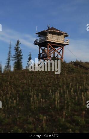 A fire lookout tower with Glacier National Park in the background Stock ...